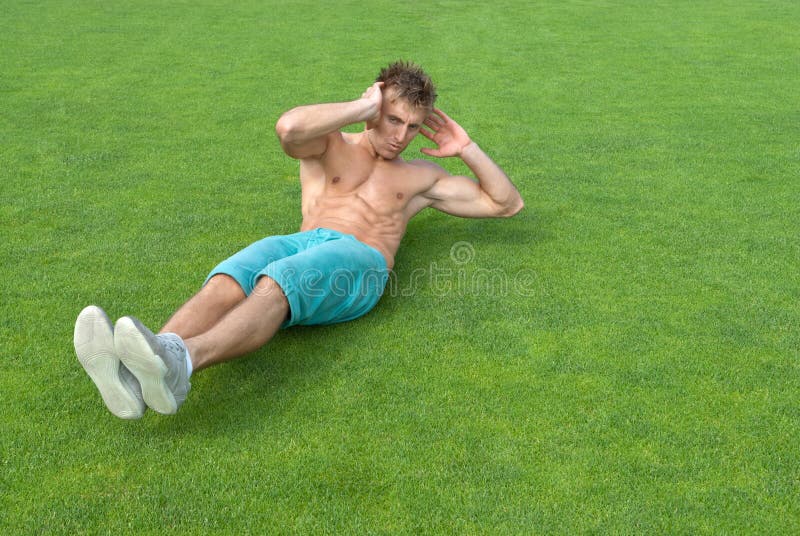 Young Man Doing Sit-ups on Green Grass Stock Photo - Image of ...