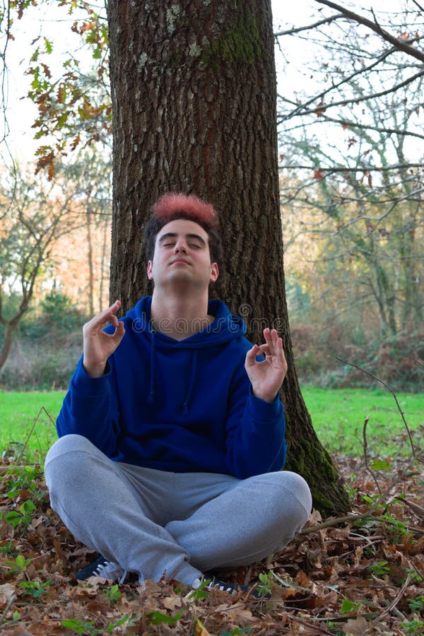 Young Man Doing Yoga and Meditating in the Middle of the Forest ...