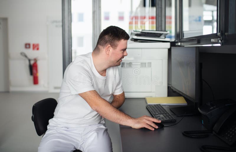 Young Man with Down Syndrome Working in Hospital Office, Writing ...