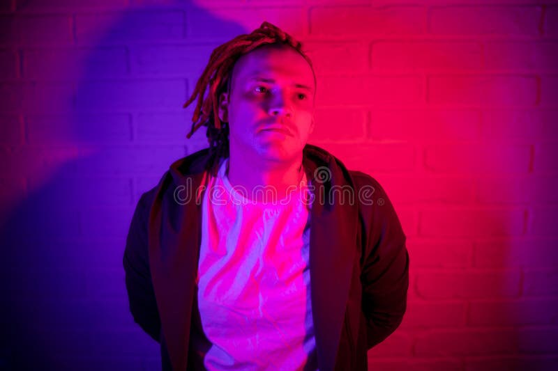 Young Man with Dreadlocks in a Pink Neon Light. Portrait of a Male ...