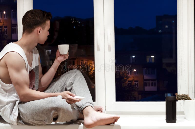 Handsome Young Man Sitting Near Window in the Evening Stock Photo ...