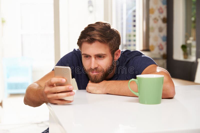 Young Man Drinking Coffee and Using Mobile Phone at Home Stock Photo ...