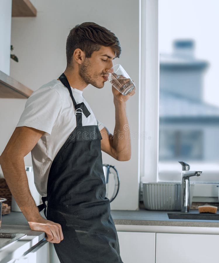 Young Man Drinks Clean Water Standing in the Home Kitchen Stock Image ...