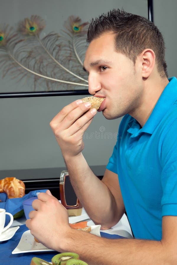 Young man eating breakfast stock photo. Image of grain - 32352044
