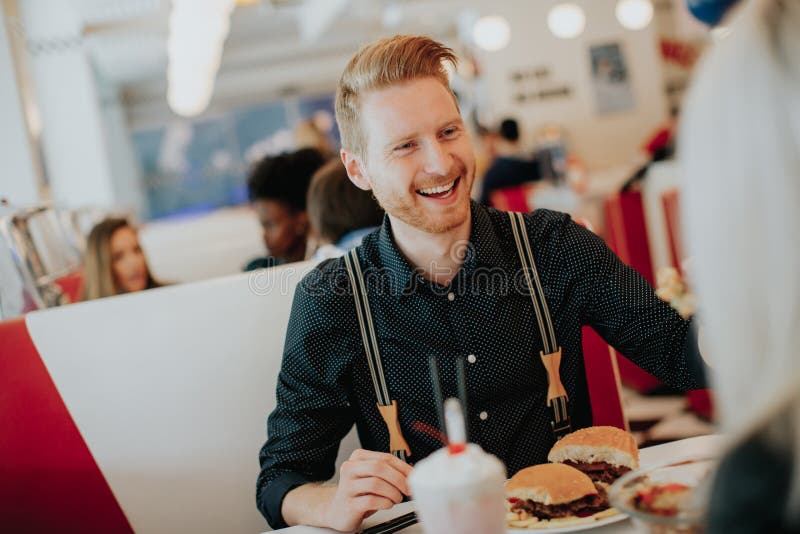 Young Man Eating Cheeseburger in Diner Stock Photo - Image of delicious ...
