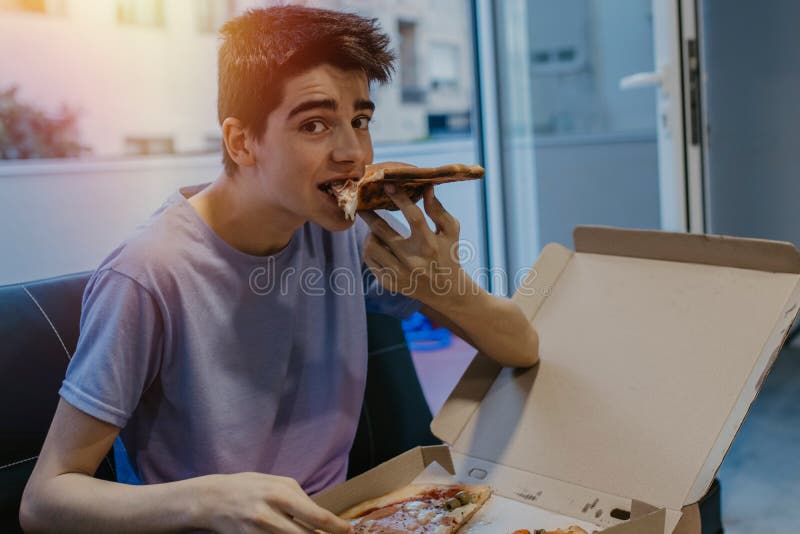Young Man Eating Pizza at Home Stock Photo - Image of home, adult ...