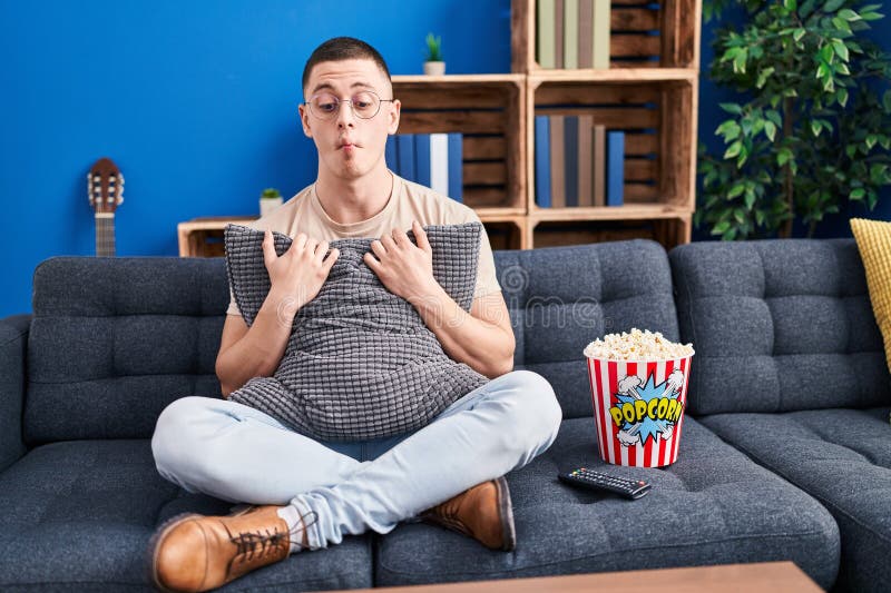 Young Man Eating Popcorn Making Fish Face with Mouth and Squinting Eyes, Crazy and Comical Stock ...