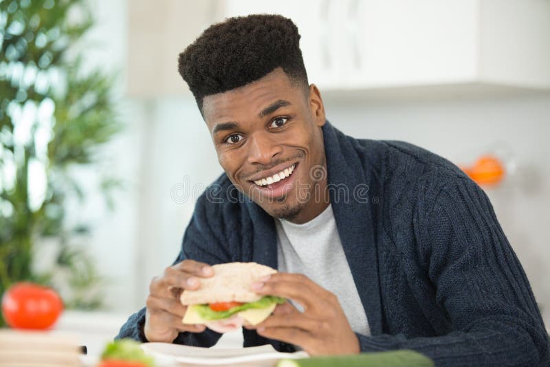 Young man eating sandwich stock image. Image of yummy - 259683091