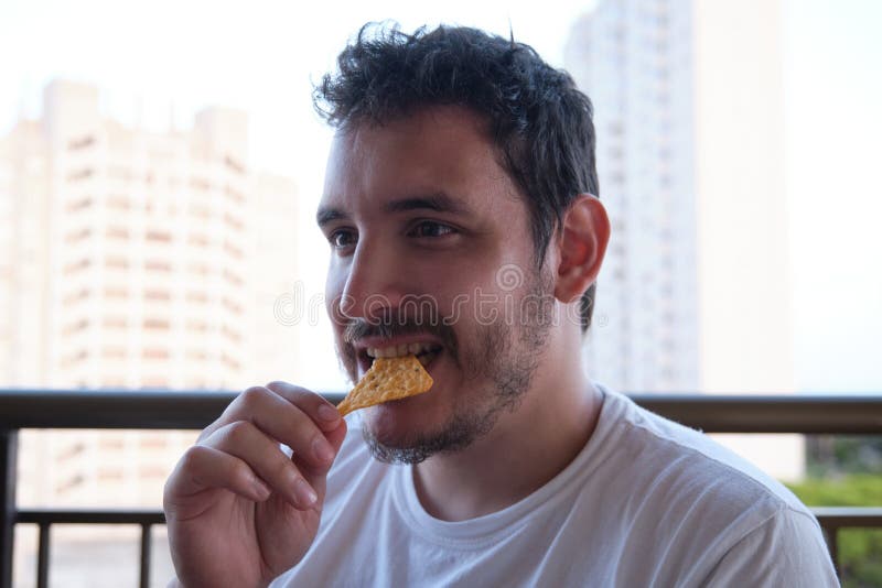 Young man eating a snack stock image. Image of carefree - 194146195