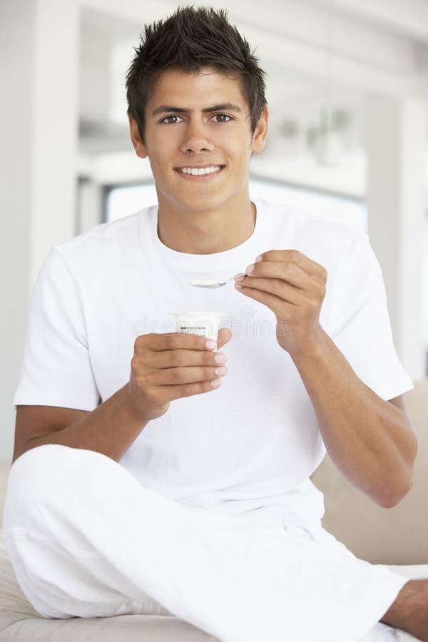 Young Man Eating Yogurt stock image. Image of home, black - 7874439