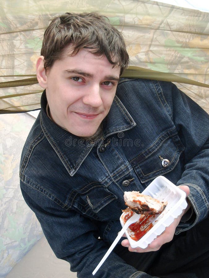 The young man eats meat stock image. Image of fork, hold - 65719459