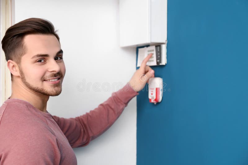 Young Man Entering Code on Security Alarm System, Indoors Stock Image ...