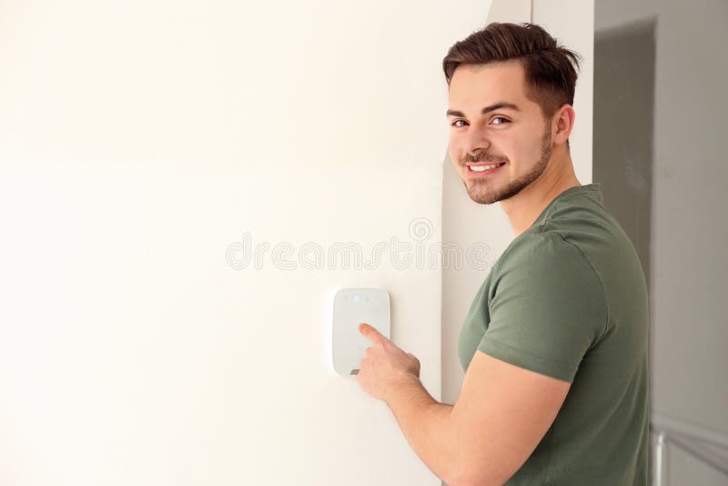 Young Man Entering Code on Security Alarm System, Indoors Stock Photo ...