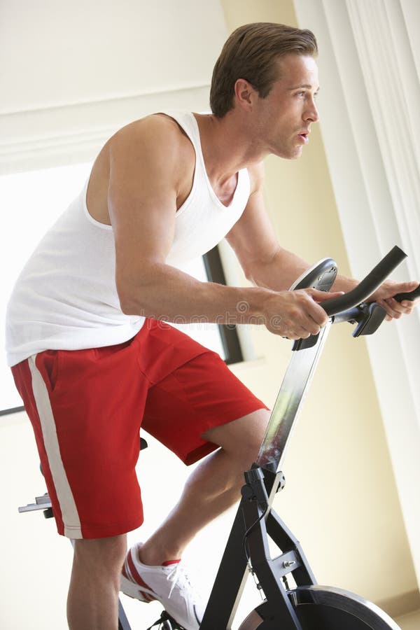 Young Man on Exercise Bike stock photo. Image of work - 55891728