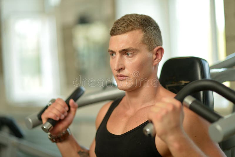 Young man exercises in gym stock photo. Image of bicep - 55104998