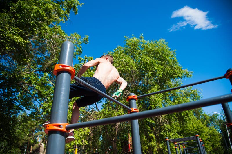 Young Man Exercising on Horizontal Bar Outdoors Stock Photo - Image of ...