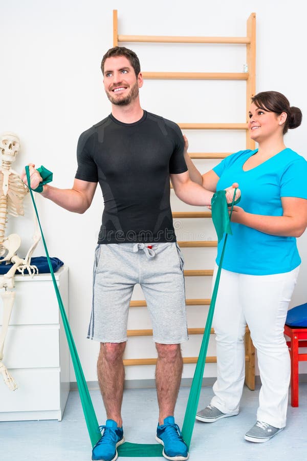 Young Man Exercising with Resistance Band in Physical Therapy Stock ...