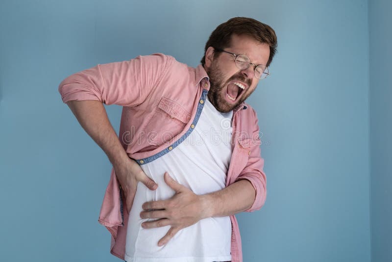 Young Man is Experiencing Severe Pain in the Abdominal Cavity, he Holds ... Young Man is Experiencing Severe Pain in the Abdominal Cavity, he Holds ...