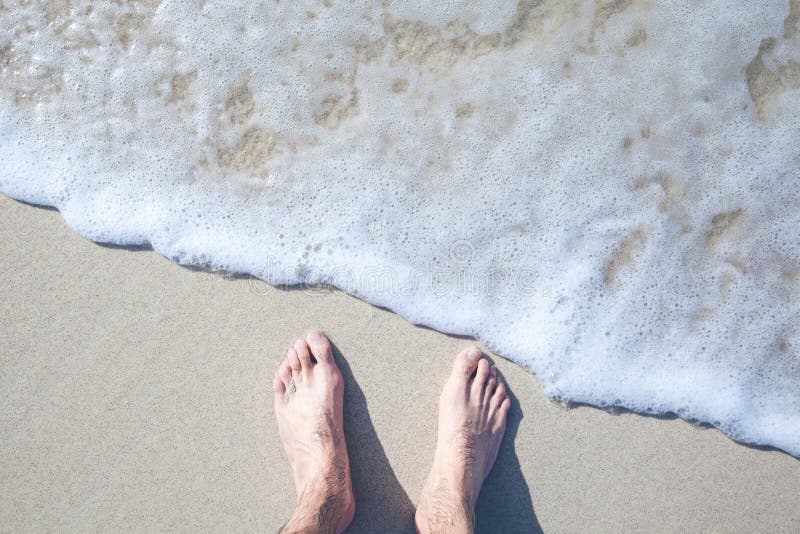 Young man feet on beach stock photo. Image of travel - 204188890