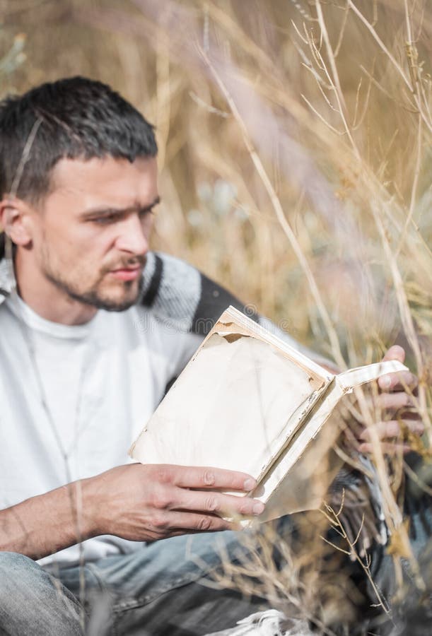 A Young Man on the Field Reading a Book Stock Image - Image of ...