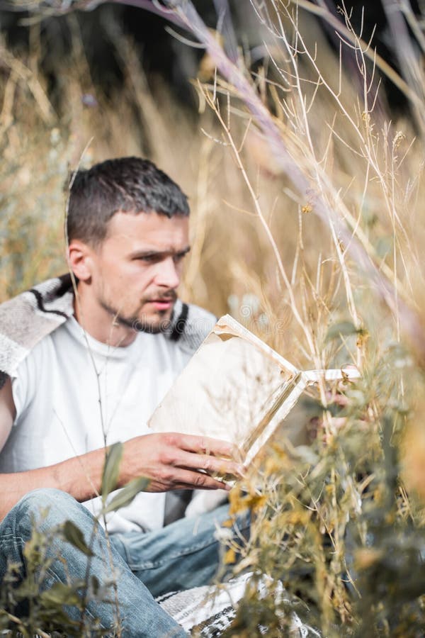 A Young Man on the Field Reading a Book Stock Photo - Image of park ...