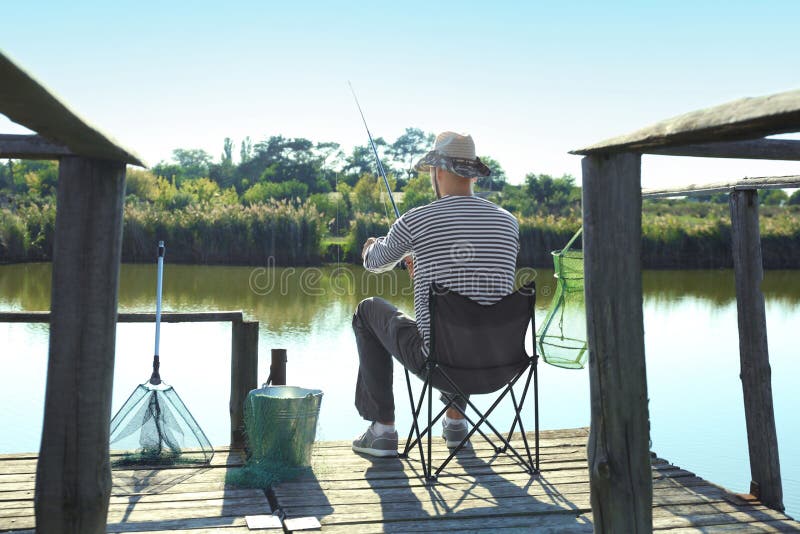 Young man fishing alone stock image. Image of pier, hobby - 129576203