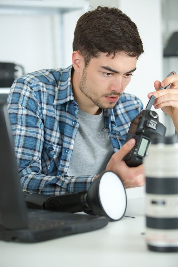 Young man fixing camera stock image. Image of computer - 118887735