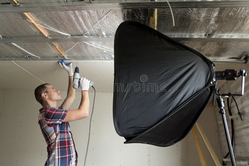 Young Man Fixing Drywall Suspended Ceiling To Metal Frame Using ...