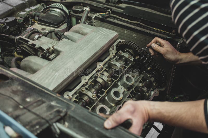 Young Man Fixing an Engine of a Car, Using a Wrench and Looking into ...