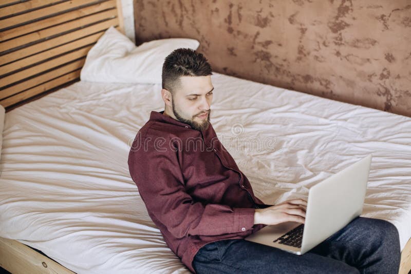 Young Man Freelancer Working on Laptop Computer in Bed Stock Photo ...