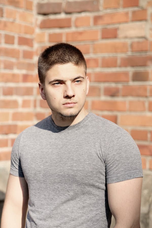 Young Man in Front of Brick Wall Stock Image - Image of adult, street ...
