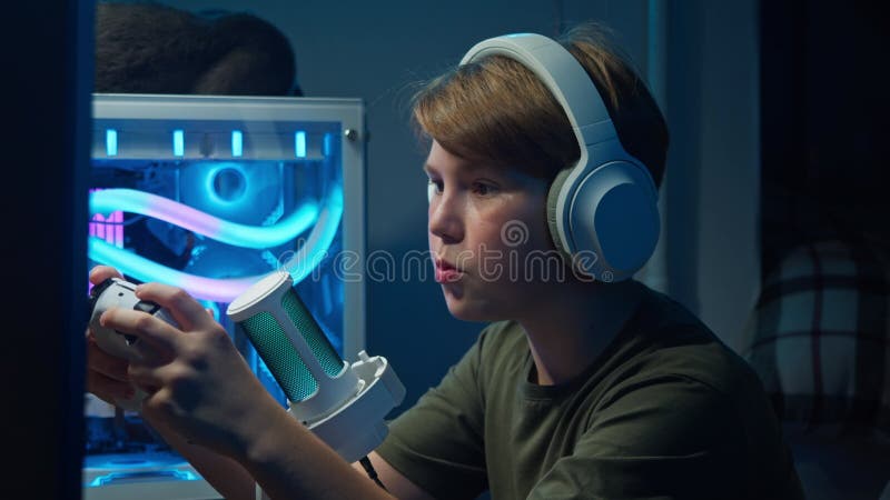 A Little Gamer Boy Actively Plays Computer Games Sitting at Home in the ...