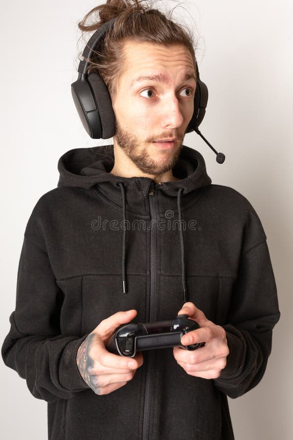 Young Man with a Gaming Headset and Controller Concentrating on a Video ...