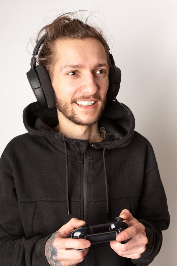 Young Man with a Gaming Headset and Controller Having Fun Playing a ...