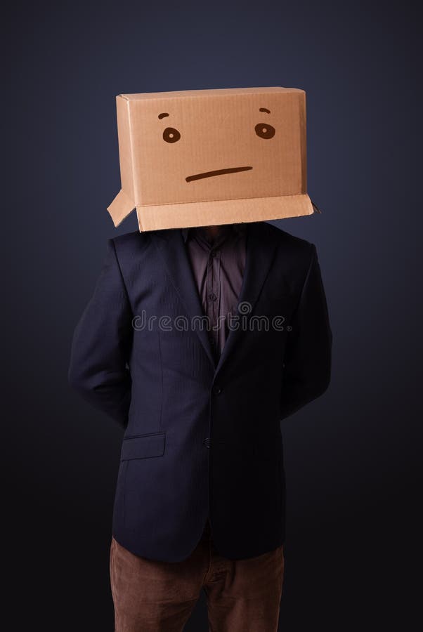 Young Man Gesturing with a Cardboard Box on His Head with Straight Face ...