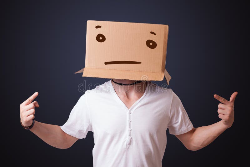 Young Man Gesturing with a Cardboard Box on His Head with Straight Face ...