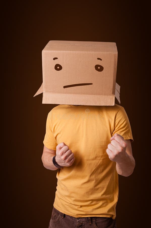 Young Man Gesturing with a Cardboard Box on His Head with Straight Face ...
