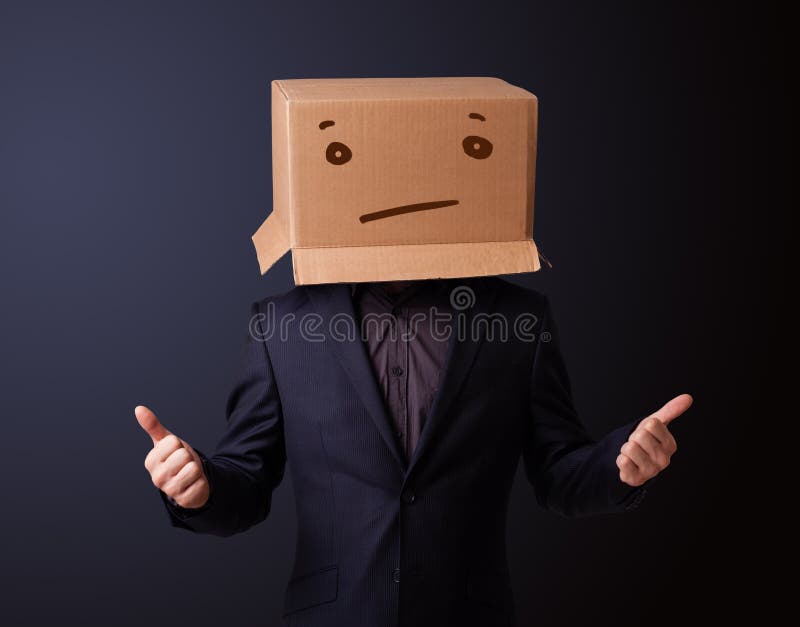Young Man Gesturing with a Cardboard Box on His Head with Straight Face ...