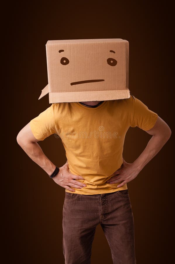 Young Man Gesturing with a Cardboard Box on His Head with Straight Face ...