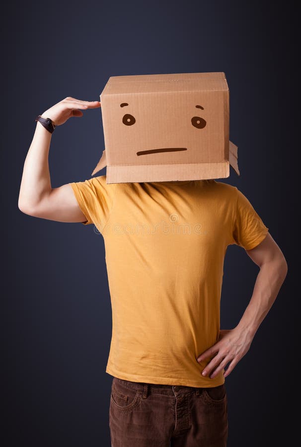 Young Man Gesturing with a Cardboard Box on His Head with Straight Face ...