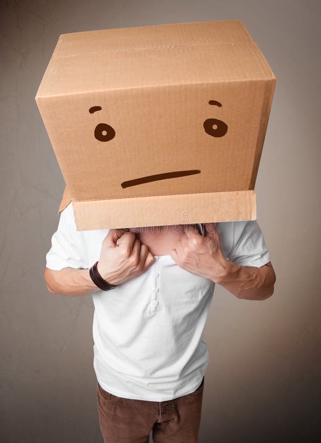 Young Man Gesturing with a Cardboard Box on His Head with Straight Face ...