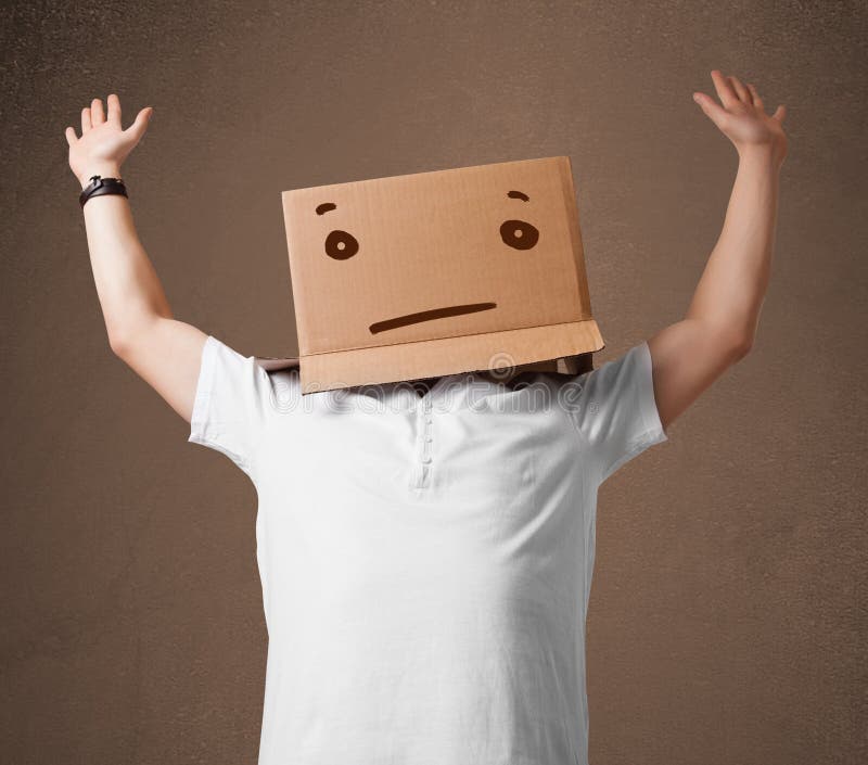 Young Man Gesturing with a Cardboard Box on His Head with Straight Face ...