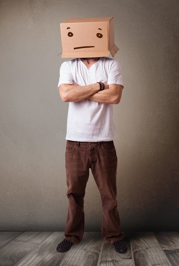 Young Man Gesturing with a Cardboard Box on His Head with Straight Face ...