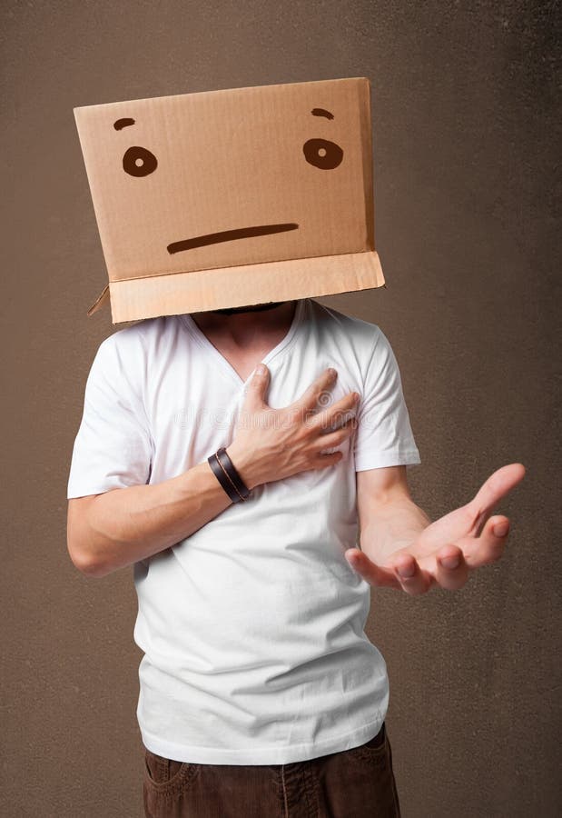 Young Man Gesturing with a Cardboard Box on His Head with Straight Face ...