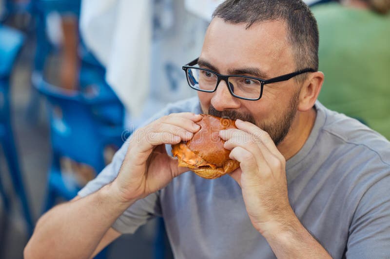 A Young Man with Glasses Eats a Burger Stock Image - Image of meal ...