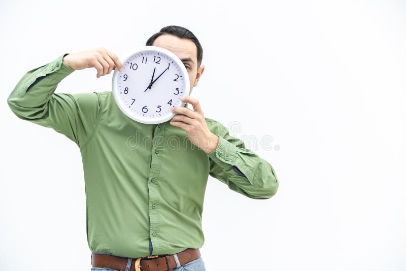 Young Man in Green is Waiting, Holding Clock in Front of His Face Over ...