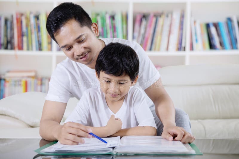 Young Man Guiding His Son To Study Stock Photo - Image of happy, parent ...