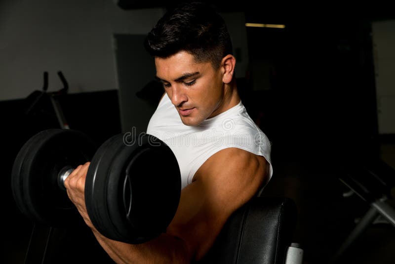 Young Man in Gym Exercising with Dumbbells Stock Photo - Image of ...