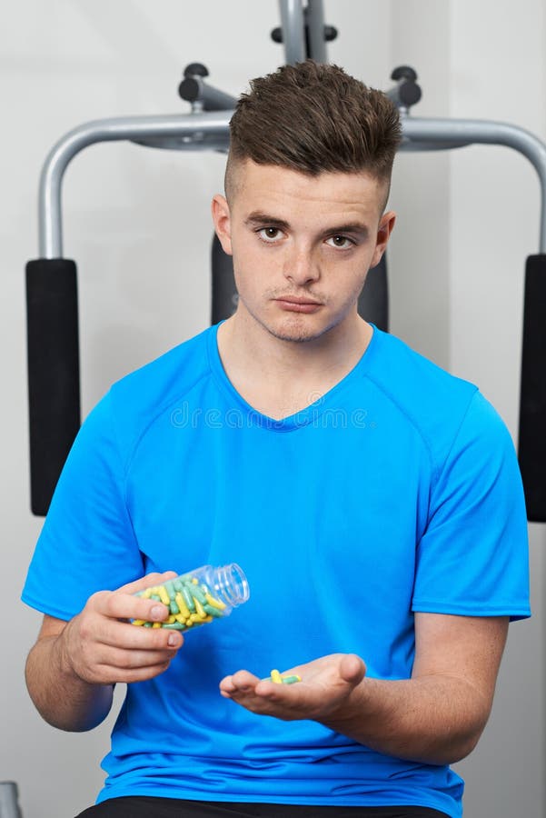 Young Man in Gym Taking Tablets Stock Image - Image of medicine, tablet ...