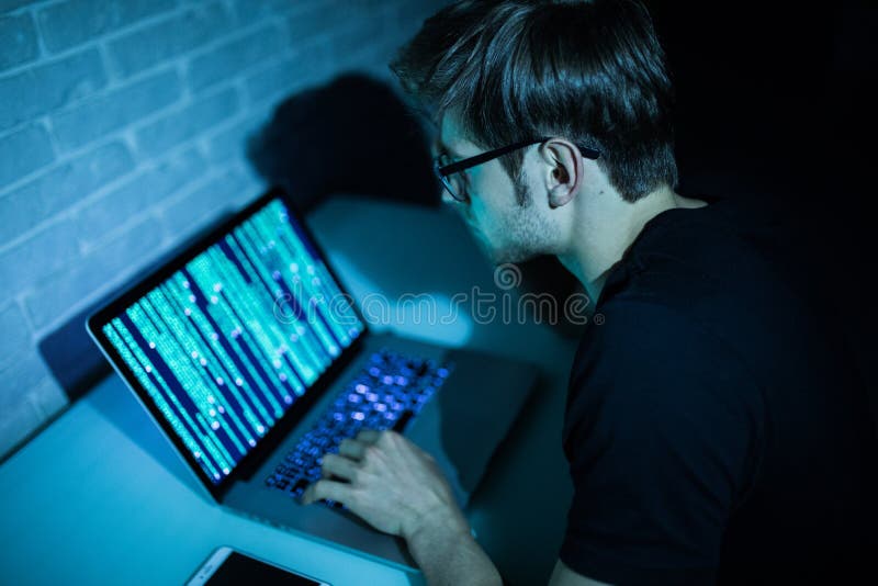 Young Man Hacker Working on Laptop Attack the Network Software in Night ...